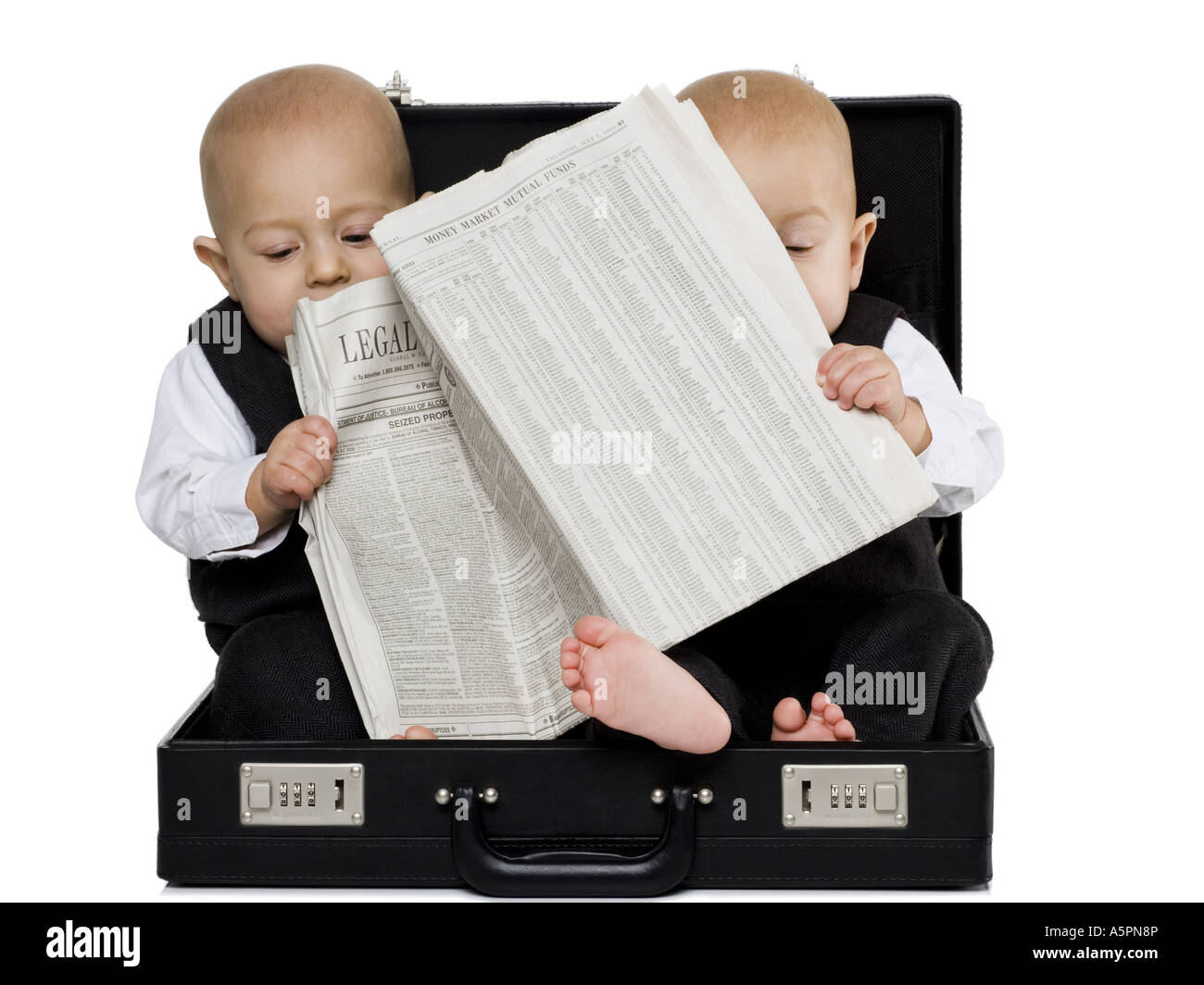 Twin boys sitting in a briefcase with newspaper Stock Photo - Alamy