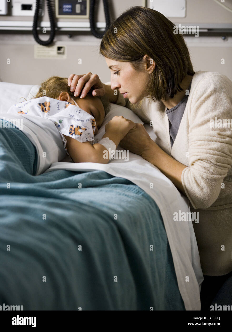 Woman kissing hand of young girl in hospital Stock Photo - Alamy