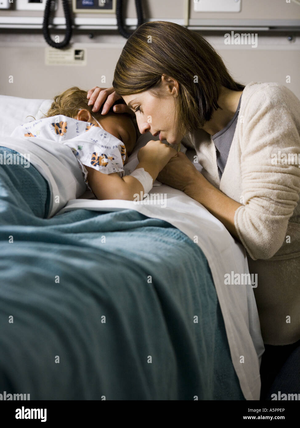 Woman kissing hand of young girl in hospital Stock Photo - Alamy