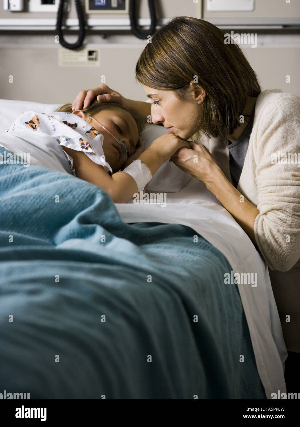 Woman kissing hand of young girl in hospital Stock Photo - Alamy