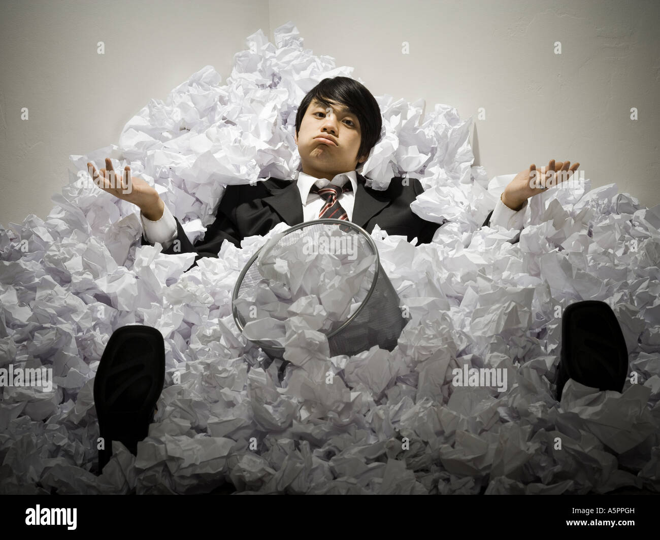 Businessman buried in mountain of crumpled papers Stock Photo - Alamy