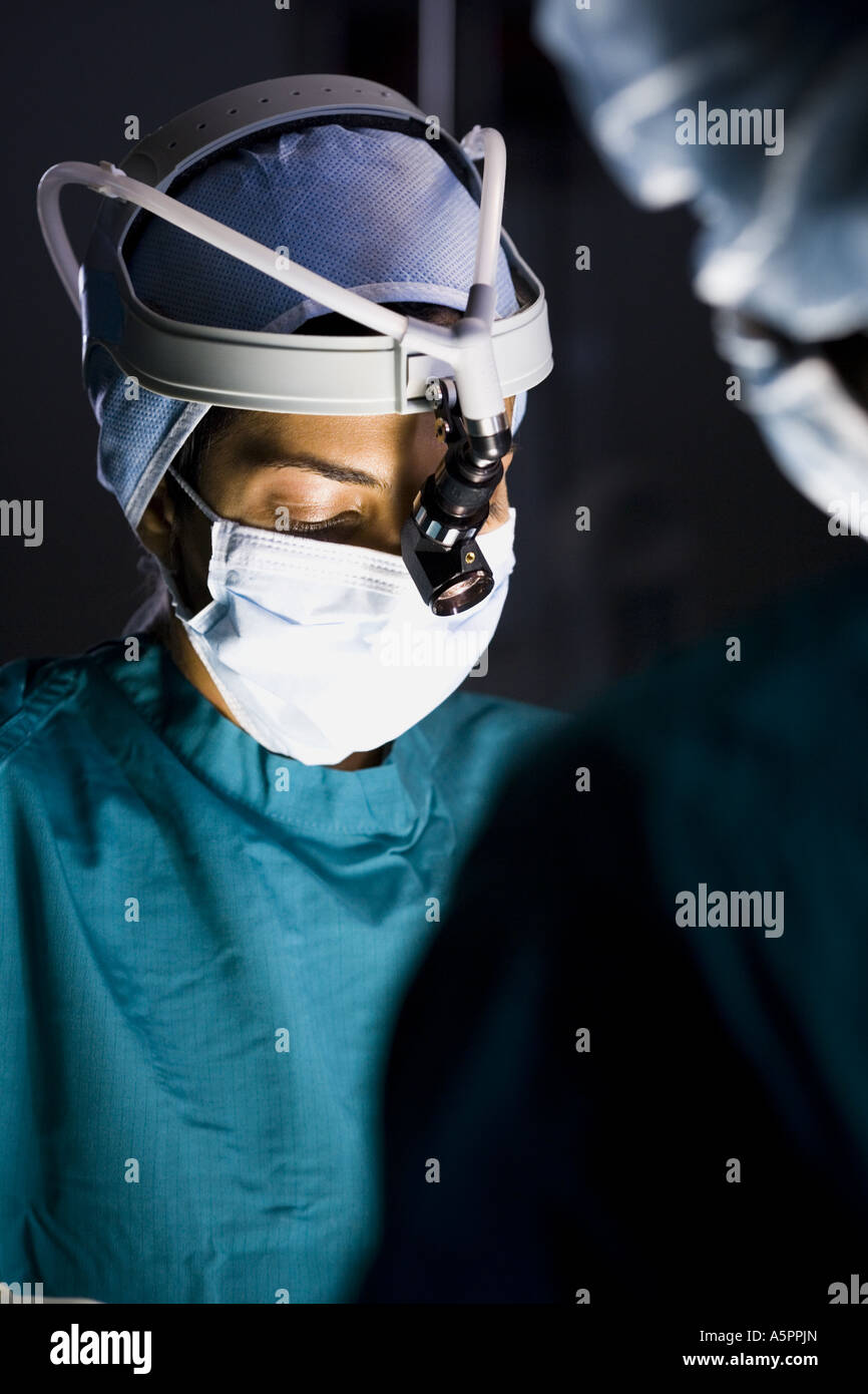 Female doctor in scrubs with head light in surgery Stock Photo - Alamy