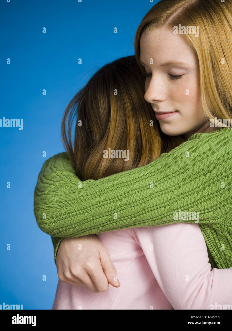 Teenage girl hugging young girl Stock Photo - Alamy