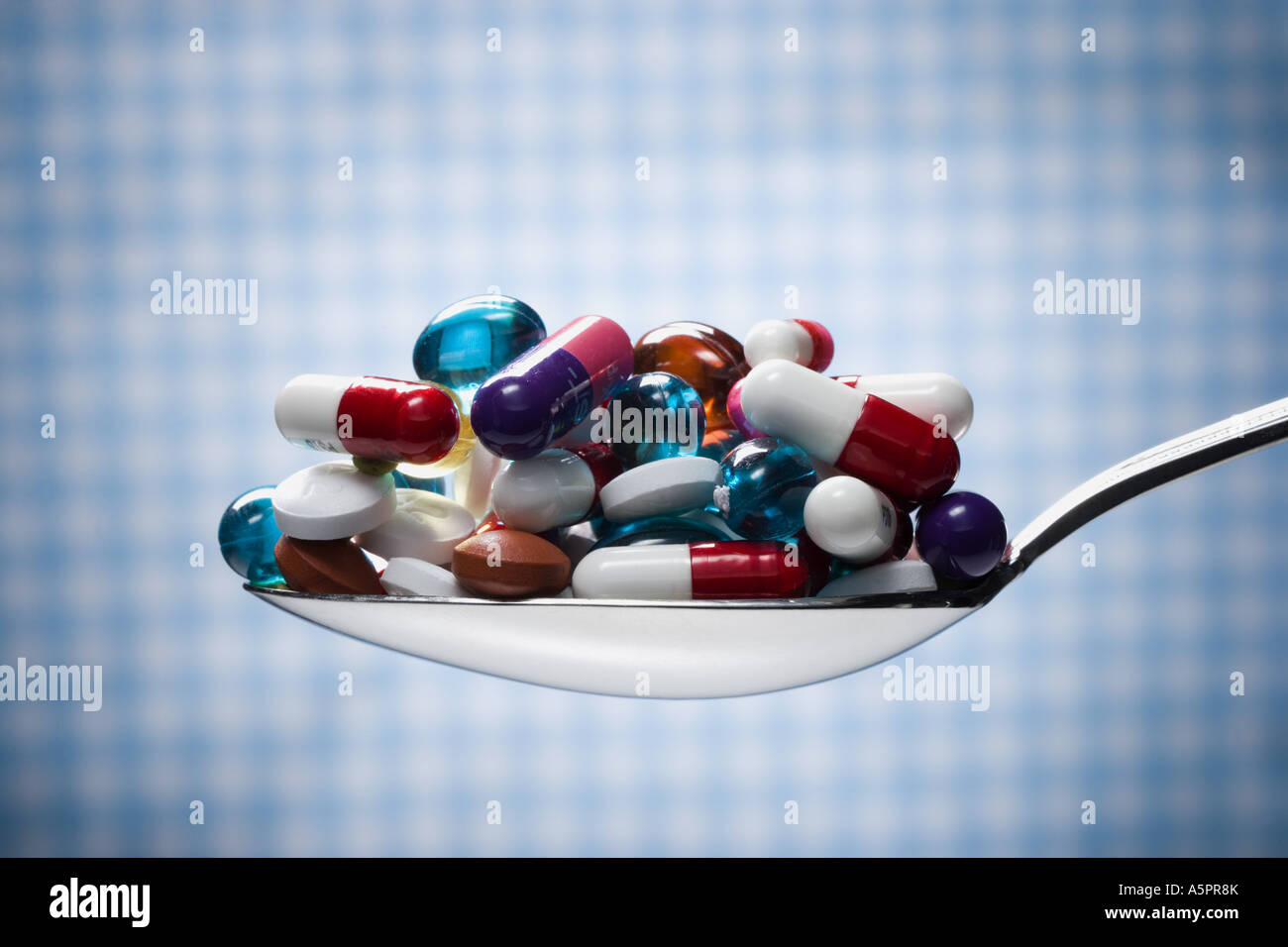 Spoonful of pills and capsules Stock Photo - Alamy