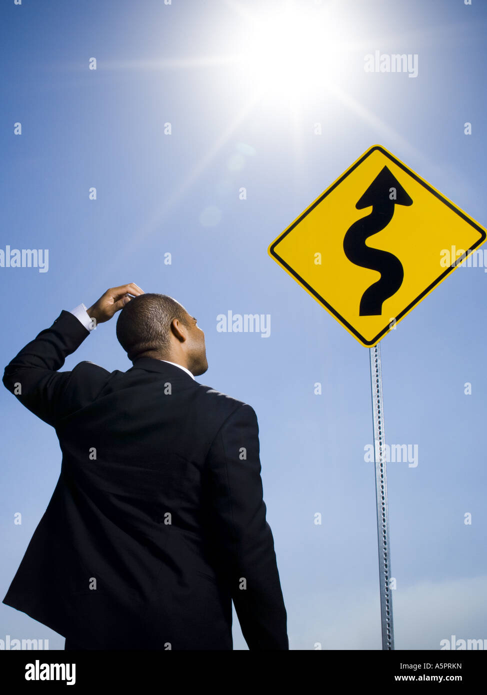 Confused businessman in front of road sign Stock Photo - Alamy
