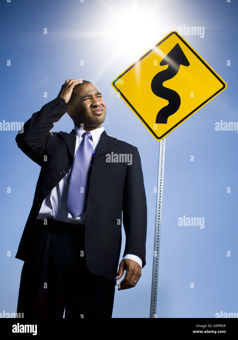 Confused businessman in front of road sign Stock Photo - Alamy