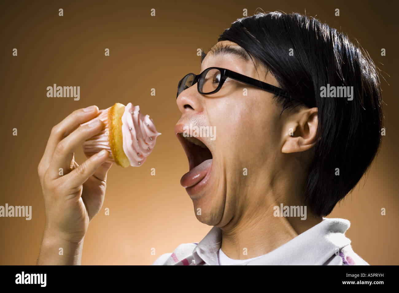 Man eating a cupcake Stock Photo - Alamy