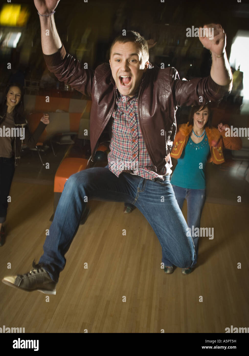 Young man jumping in excitement in a bowling alley Stock Photo - Alamy