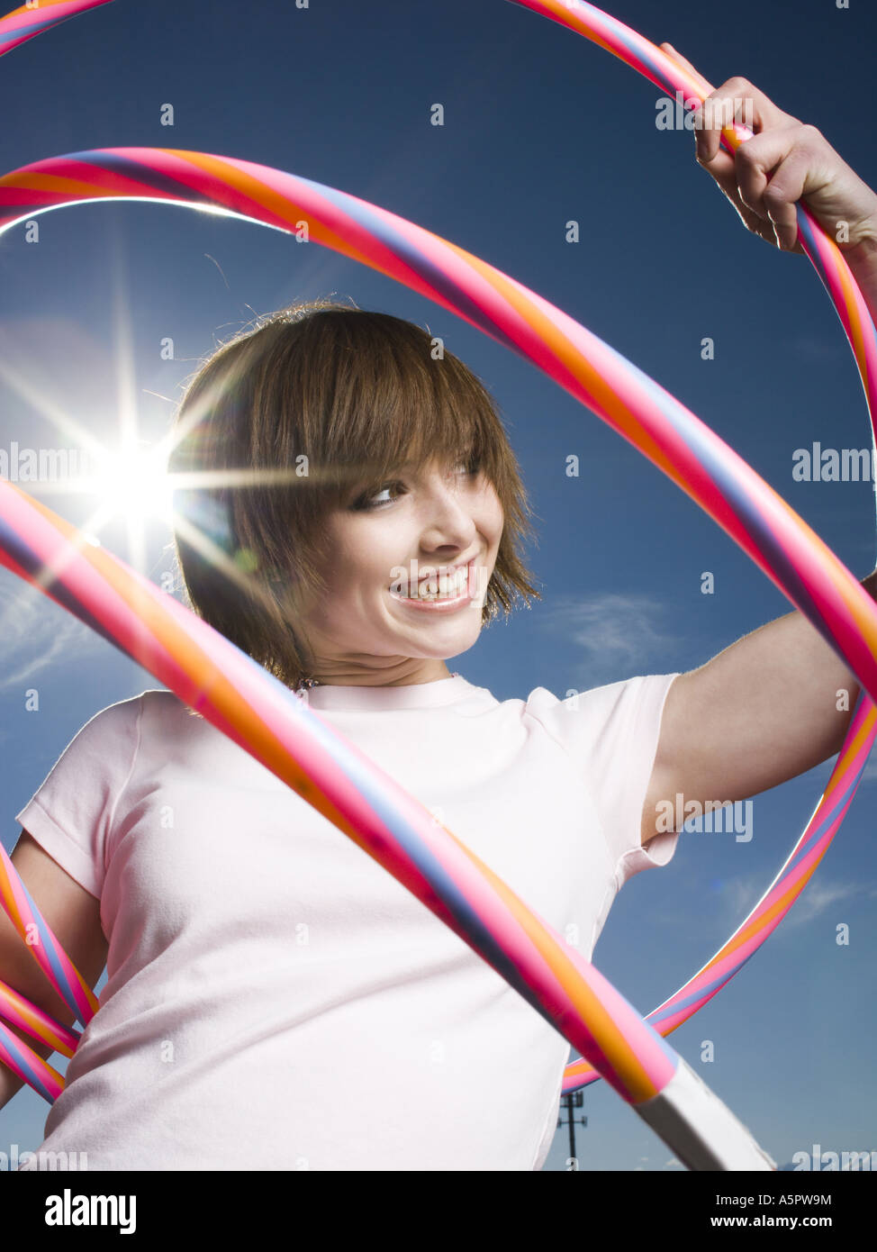 Portrait of a teenage girl holding plastic hoops Stock Photo - Alamy