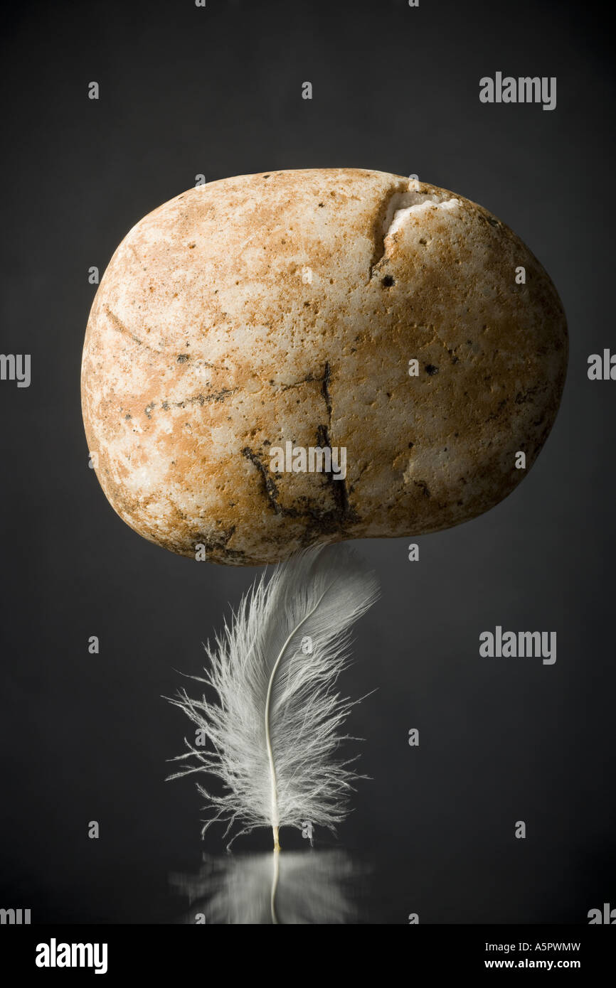 Rock and feather Stock Photo - Alamy