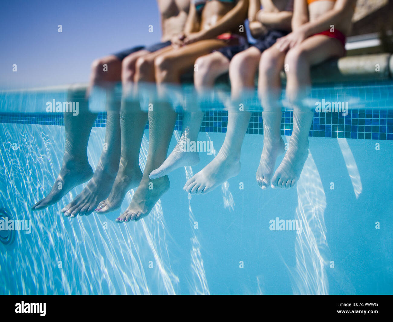 Feet dangling in swimming pool Stock Photo - Alamy