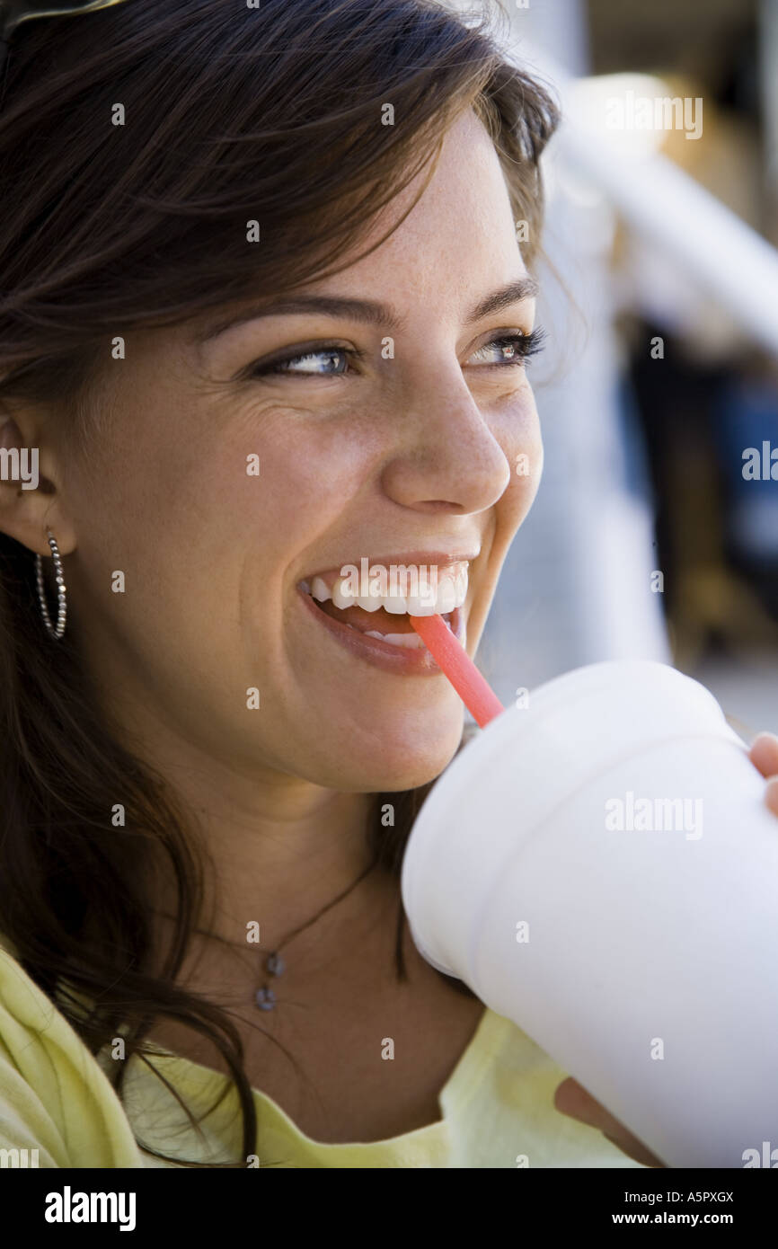 Woman drinking beverage through a straw Stock Photo - Alamy