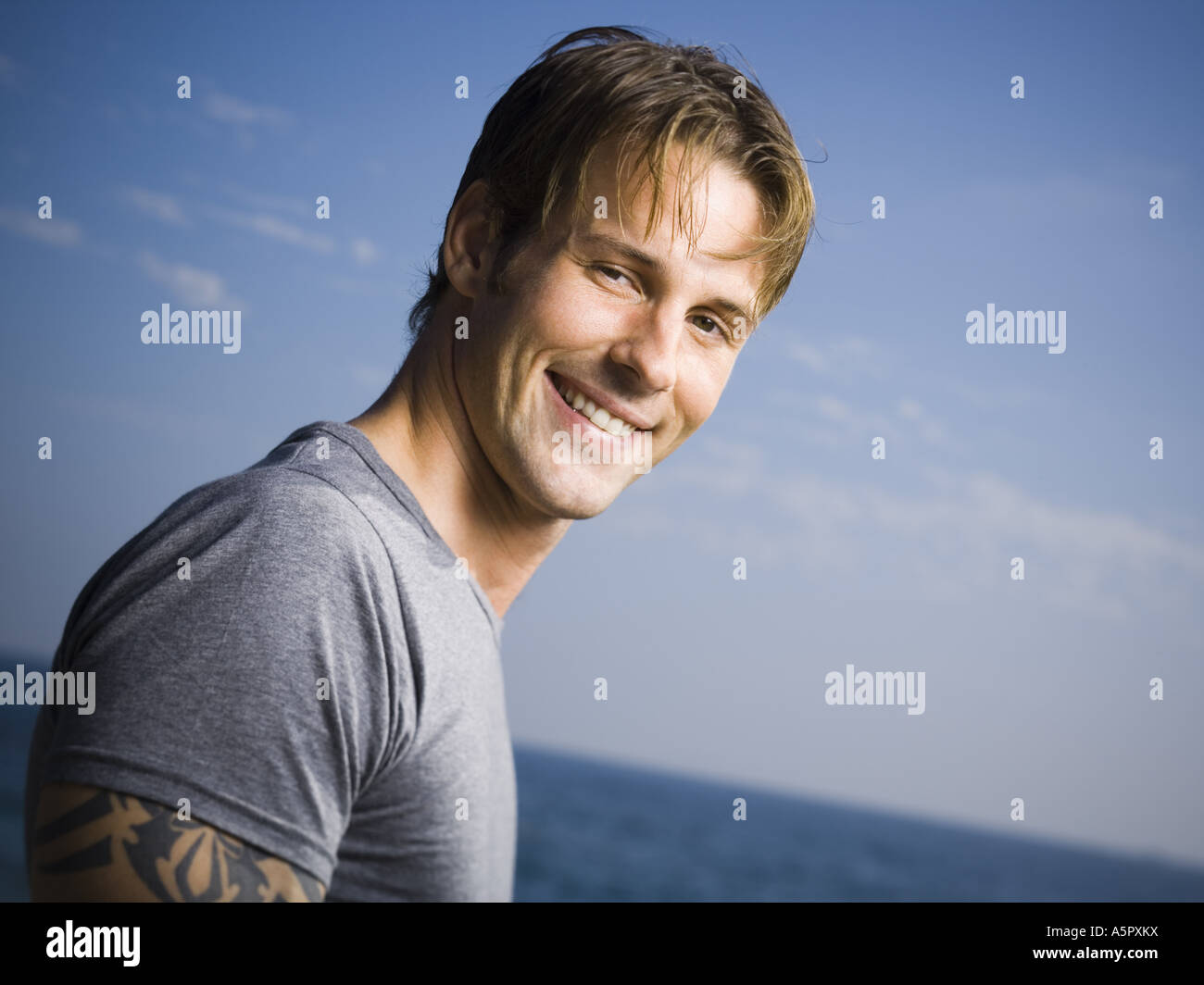 Smiling man on beach Stock Photo - Alamy