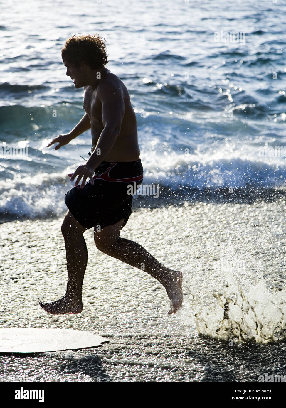 Man running in the surf on a beach Stock Photo - Alamy