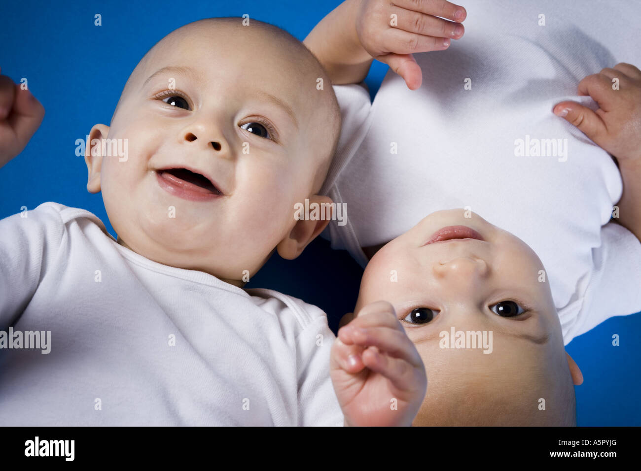 Twin babies looking up Stock Photo - Alamy