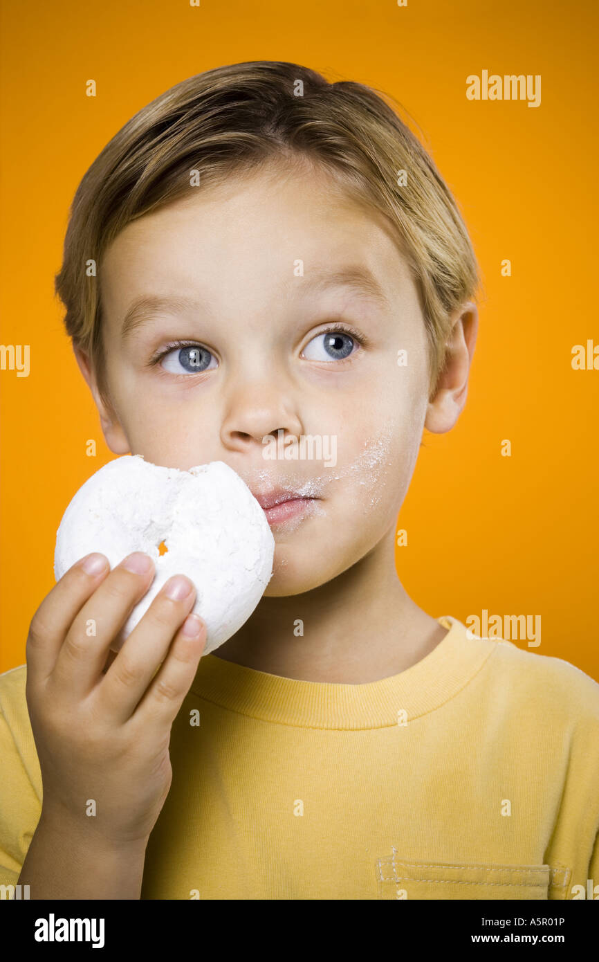 Boy eating donut Stock Photo - Alamy