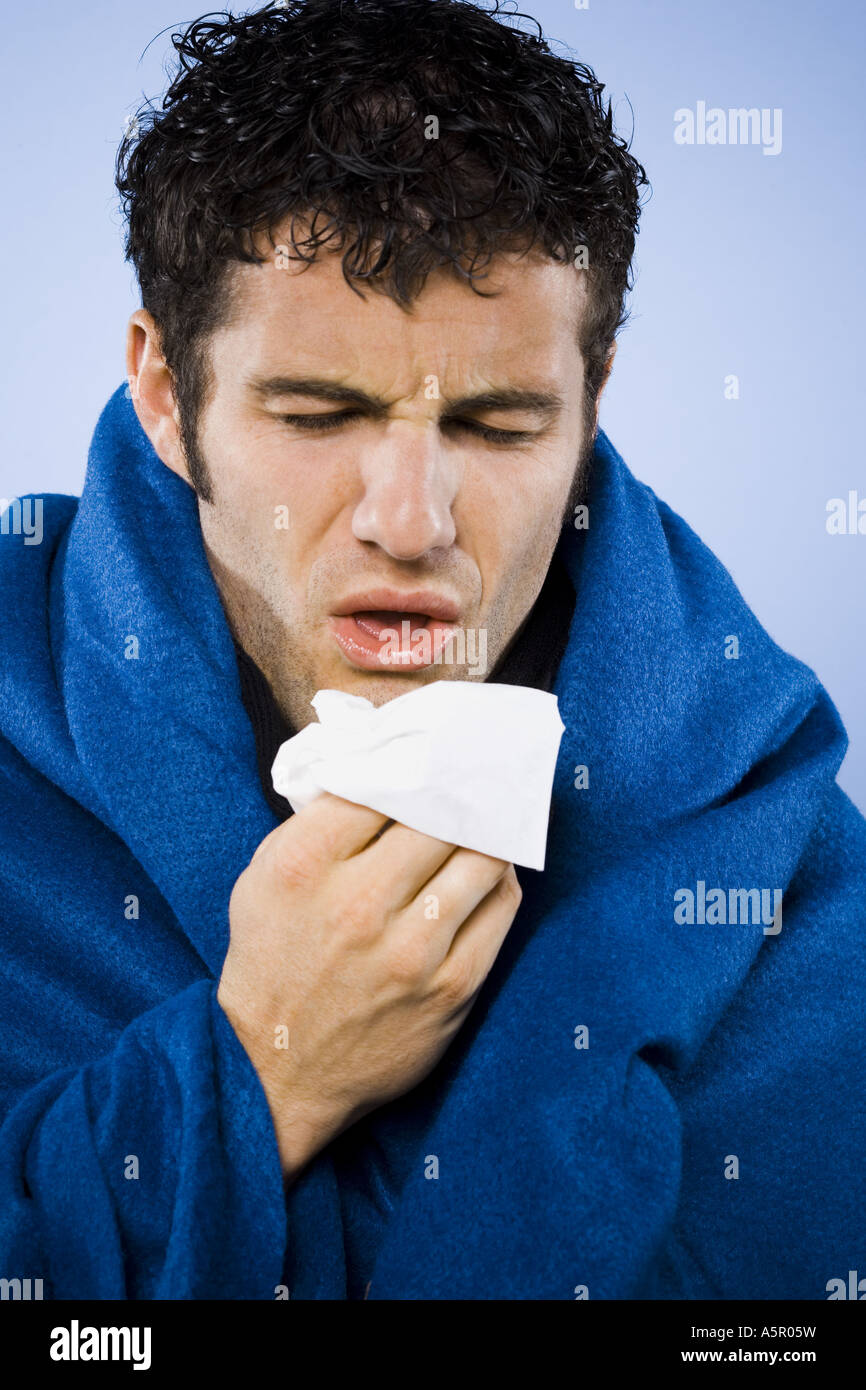 Man wrapped in blanket with tissue Stock Photo - Alamy