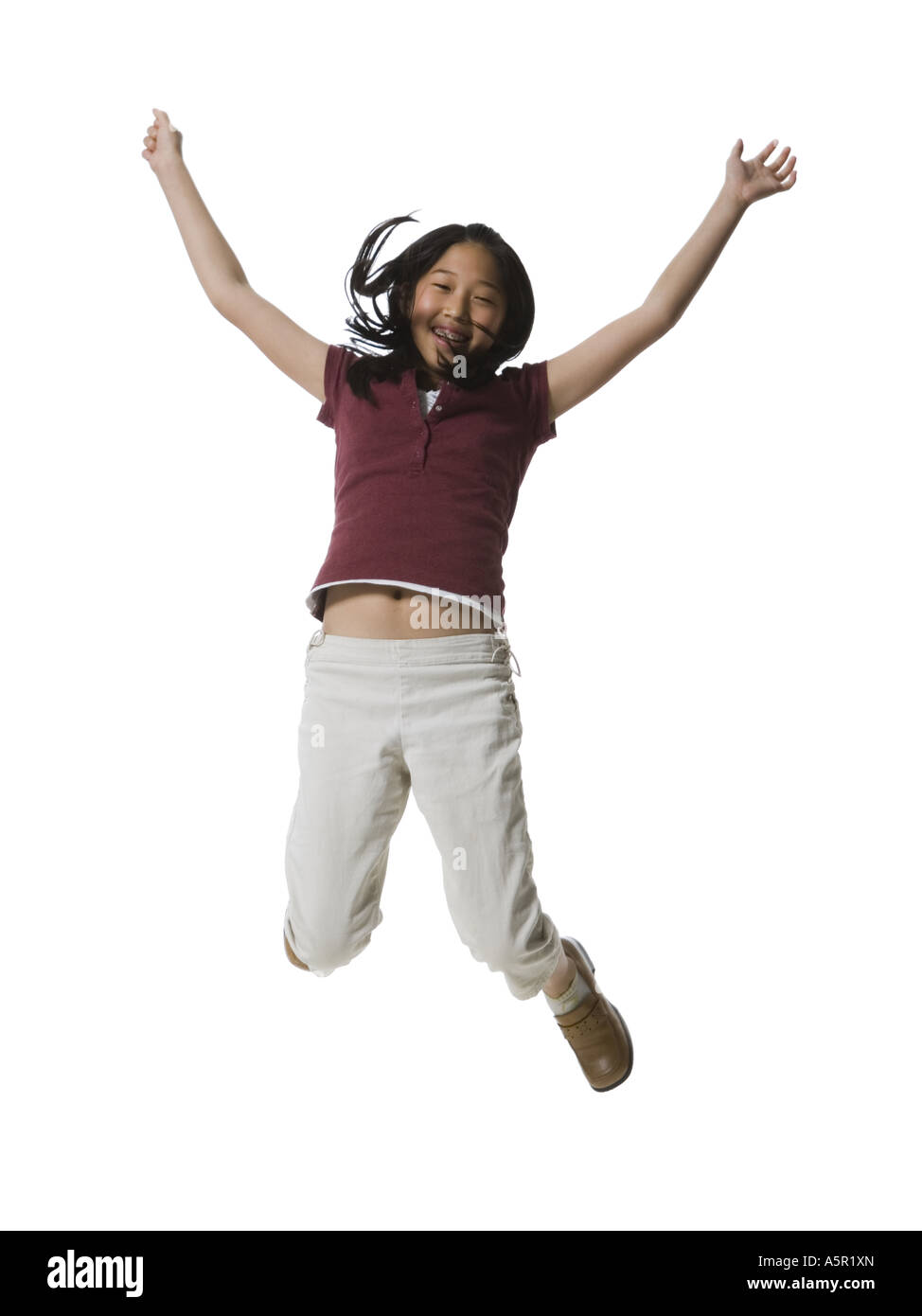 Portrait of a teenage girl jumping with her arms outstretched Stock ...