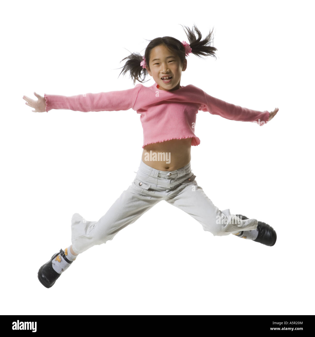 Girl jumping with her arms outstretched Stock Photo - Alamy