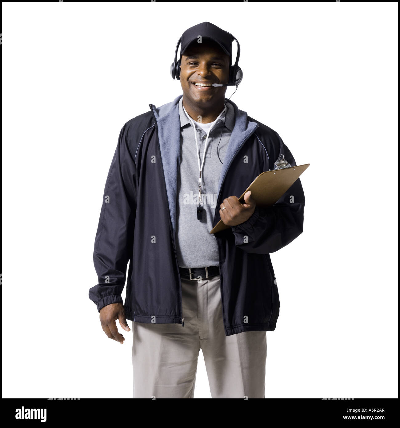 Coach with clipboard and headset smiling Stock Photo - Alamy