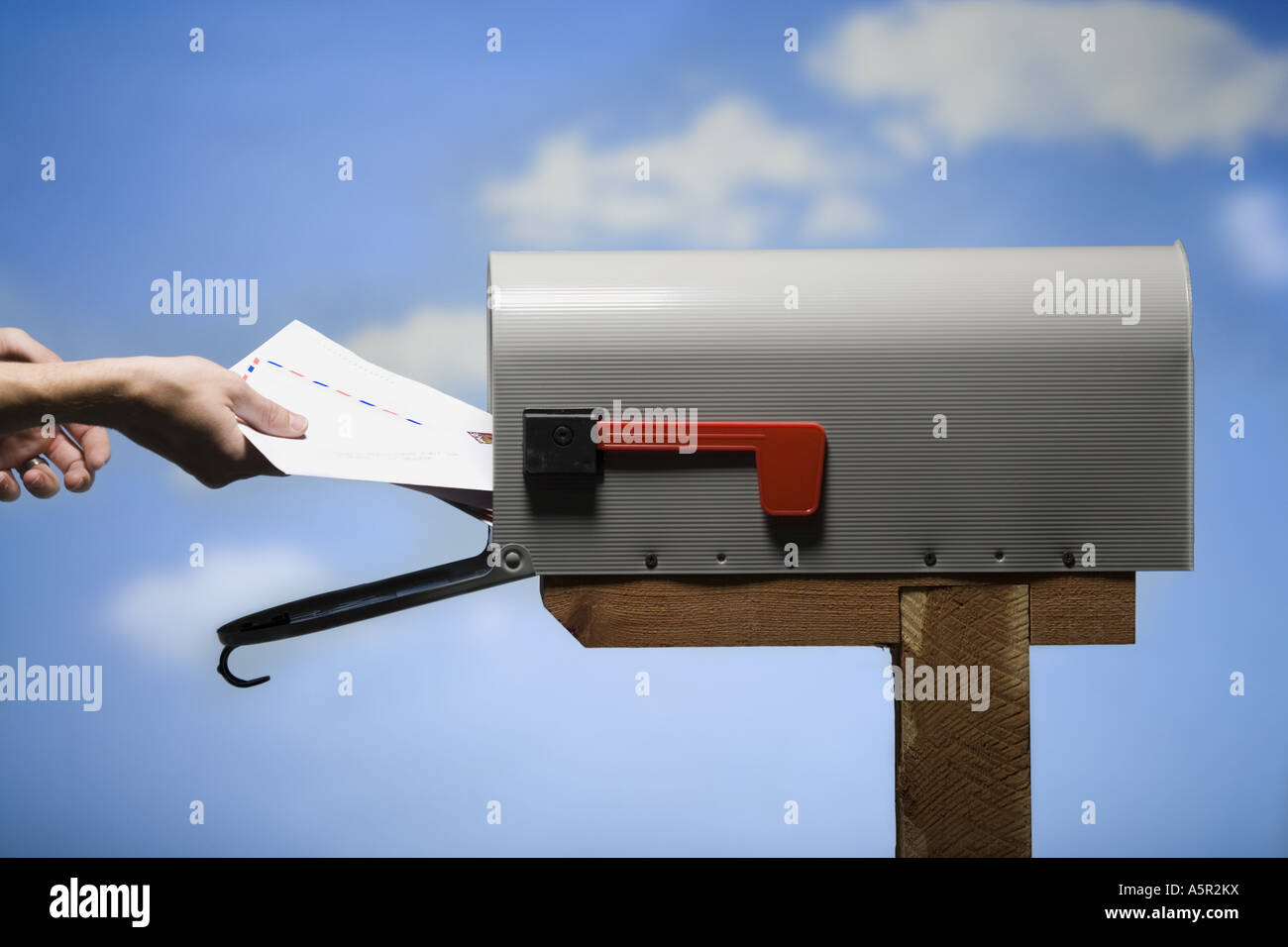 Woman getting mail from letterbox Stock Photo - Alamy