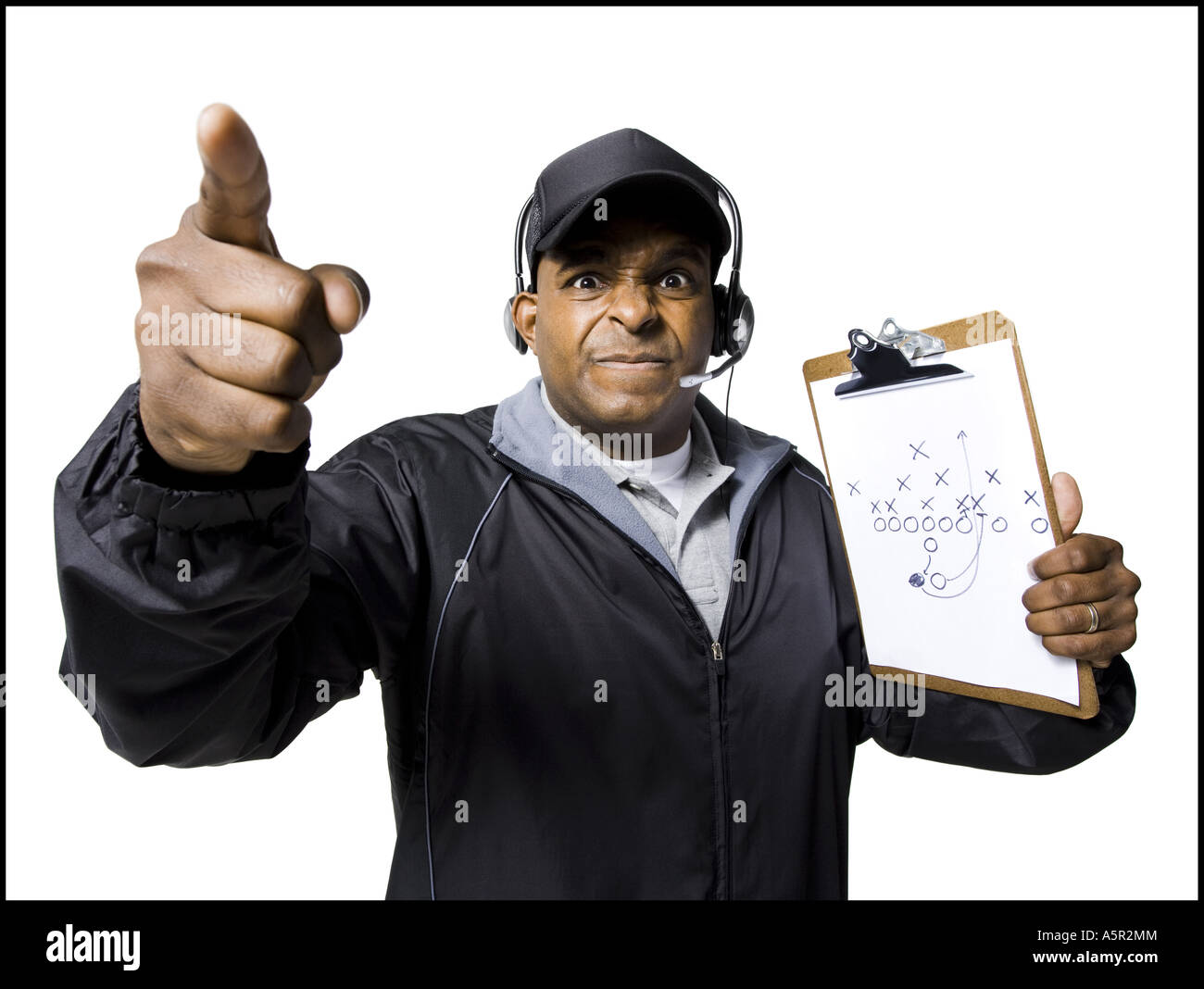 Male head coach pointing finger with headset Stock Photo - Alamy
