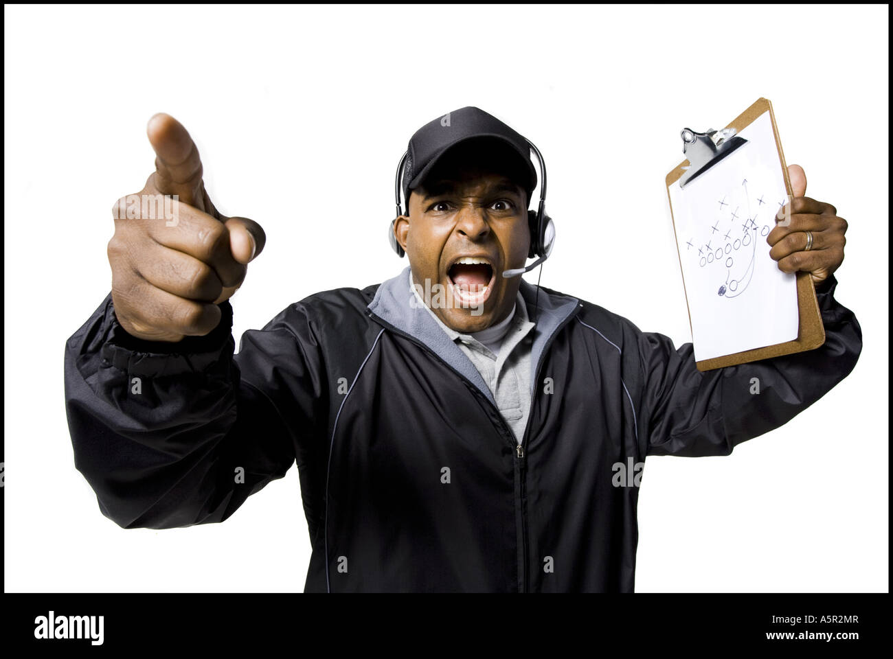 Male head coach pointing finger with headset Stock Photo - Alamy