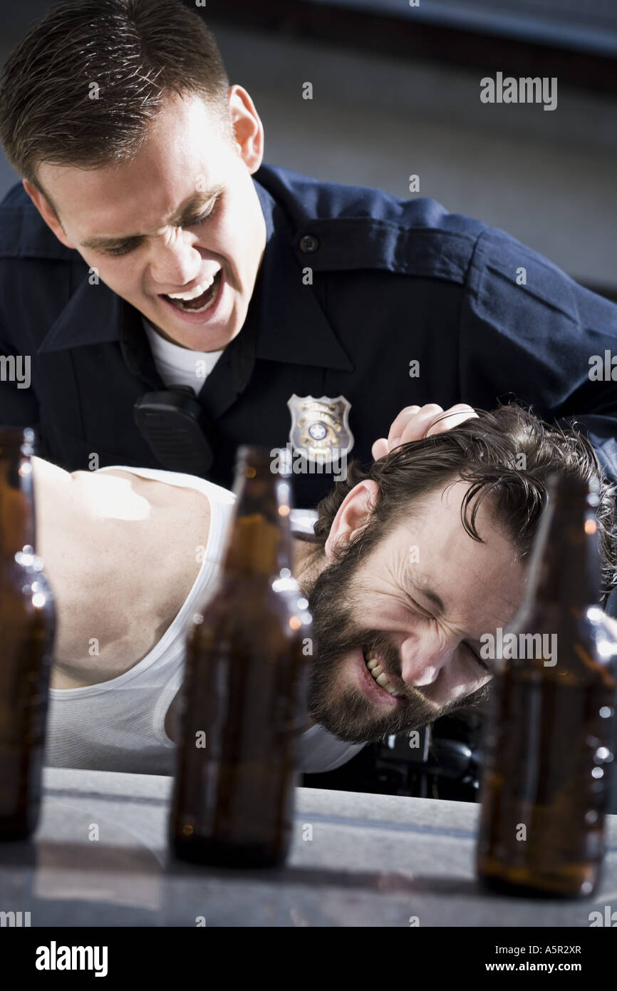 Police officer arresting man lying down with beer bottles Stock Photo ...