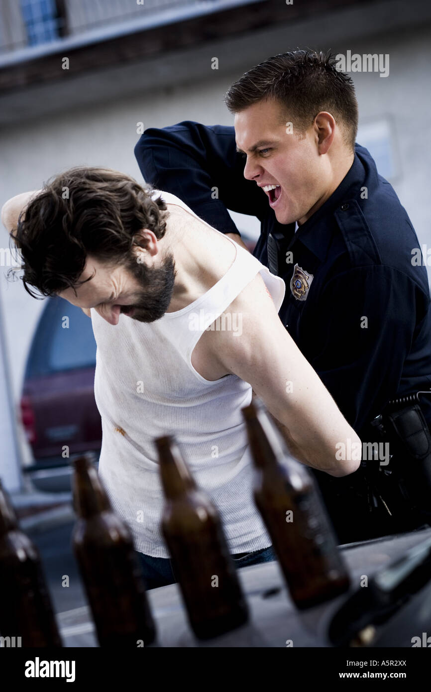 Police officer arresting man lying down with beer bottles Stock Photo ...