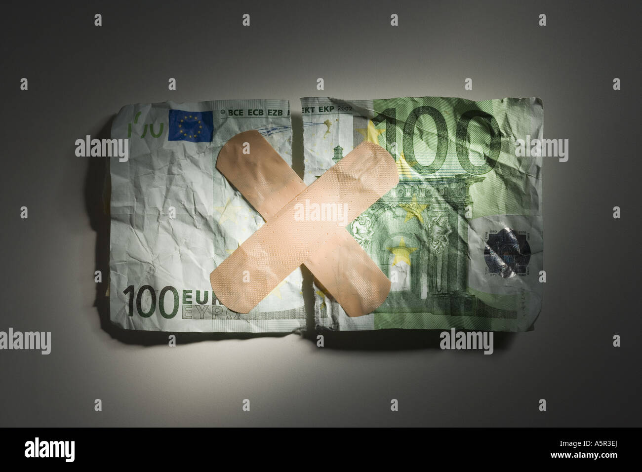 Torn one hundred euro banknote with bandages Stock Photo - Alamy