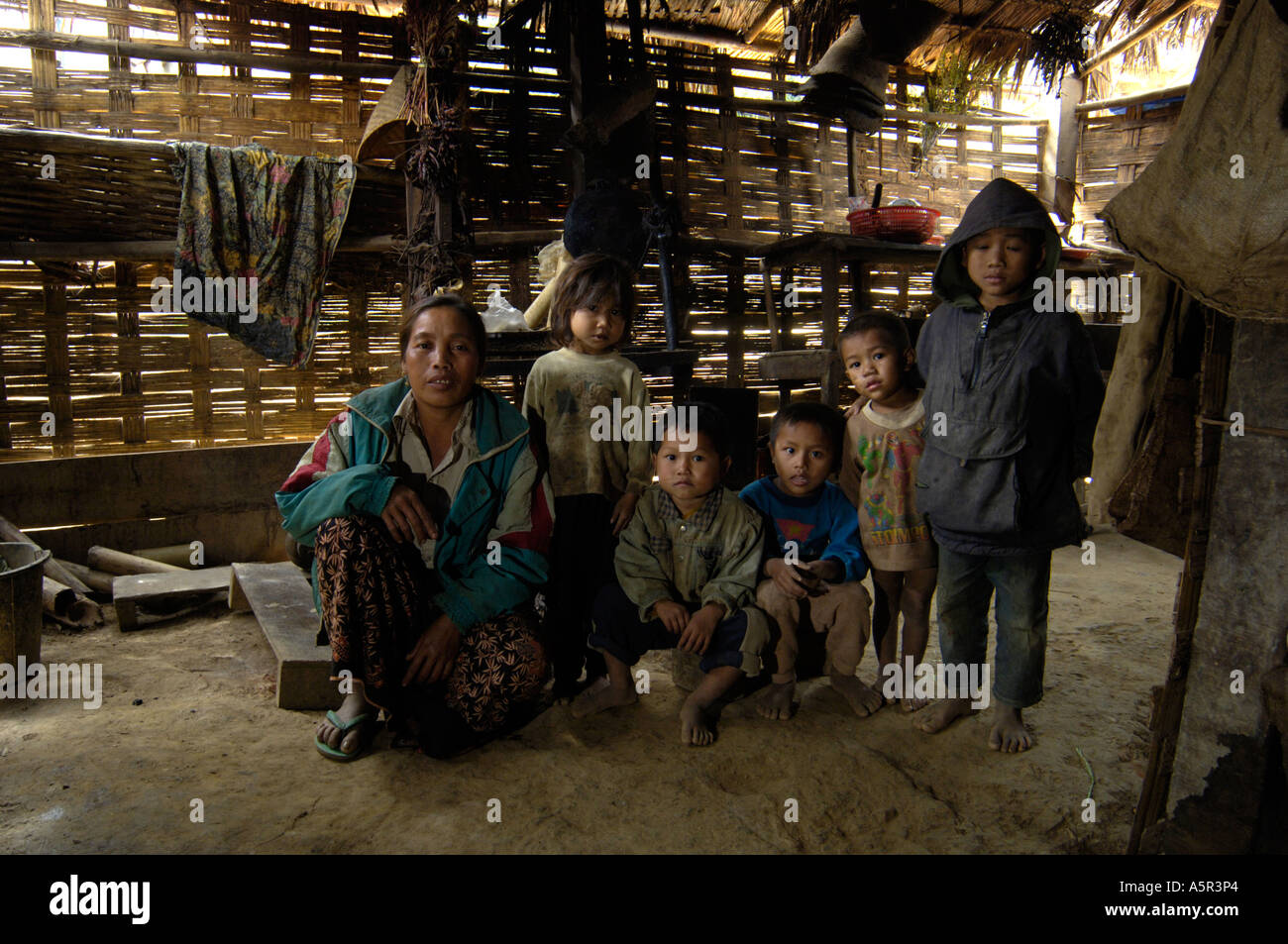 Khamu ethnic minority villagers in dirt floor kitchen Luang Prabang ...