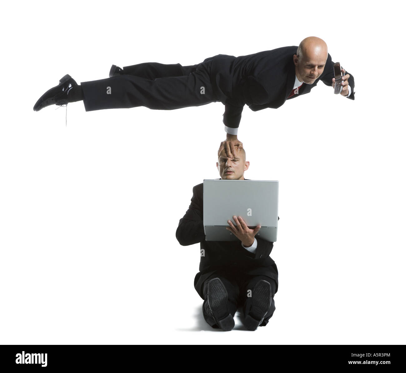 Two male acrobats in business suits performing Stock Photo - Alamy