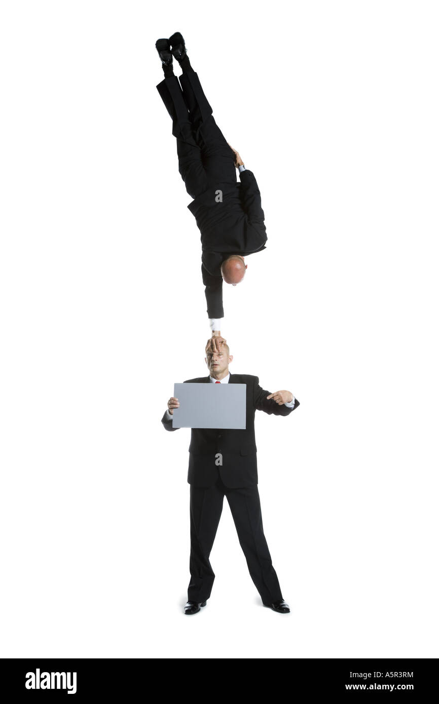 Two male acrobats in business suits performing Stock Photo - Alamy