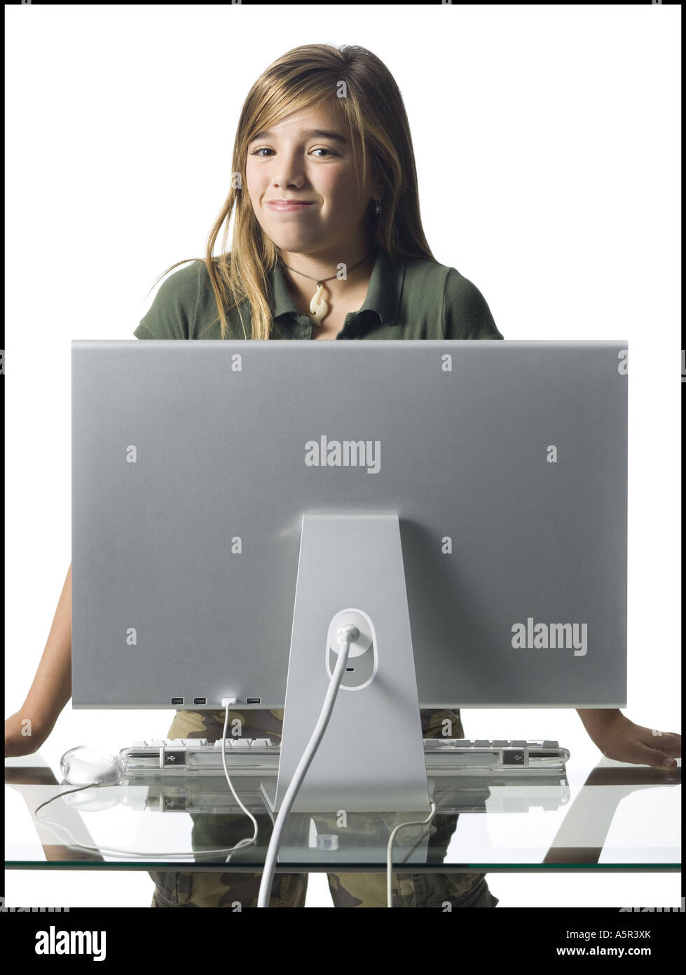 Girl standing behind computer monitor smiling Stock Photo - Alamy