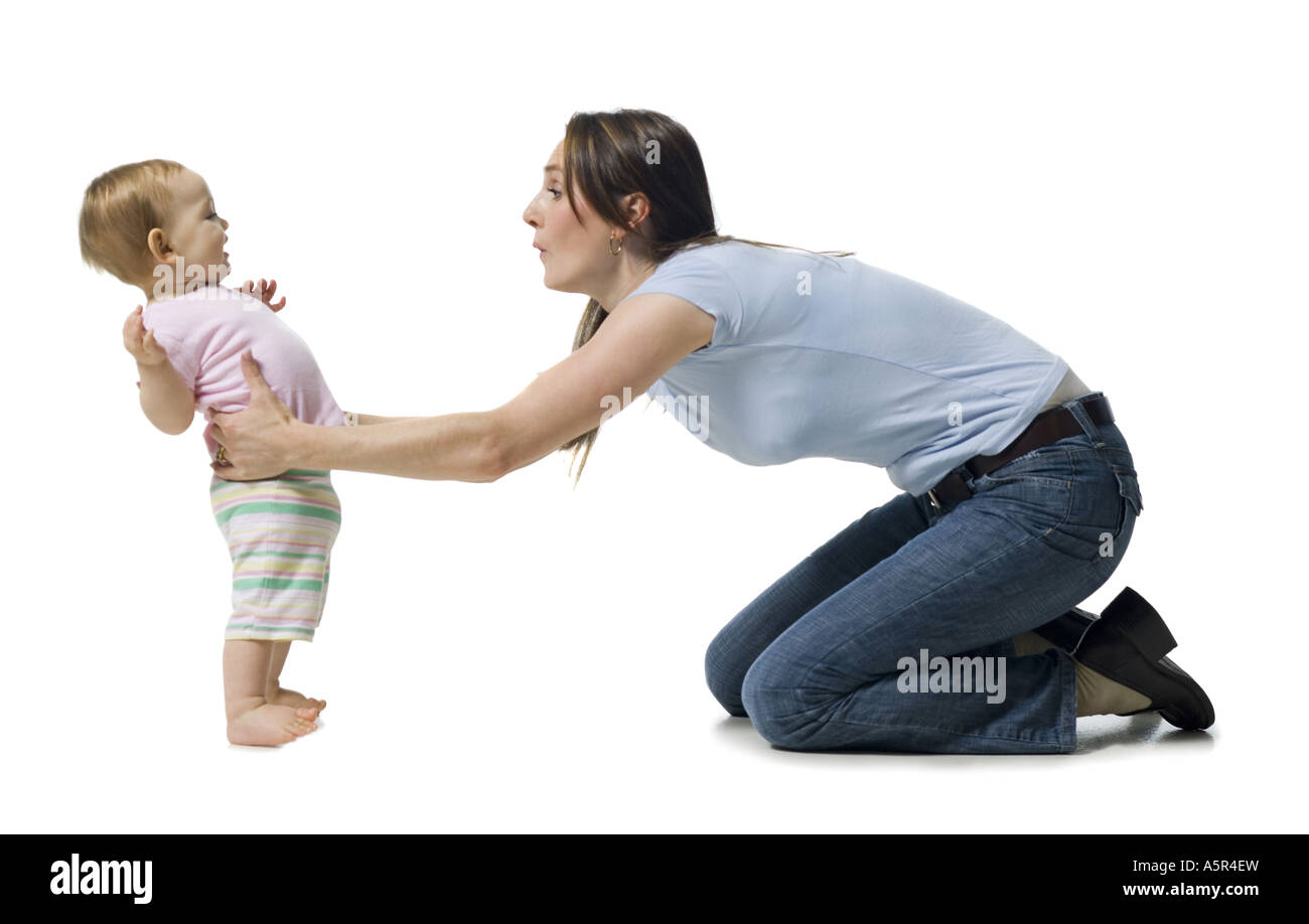 Baby girl walking to mother Stock Photo - Alamy