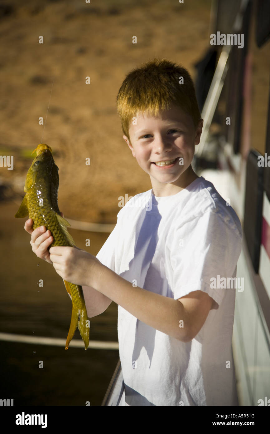 Boy on boat outdoors with fish Stock Photo - Alamy