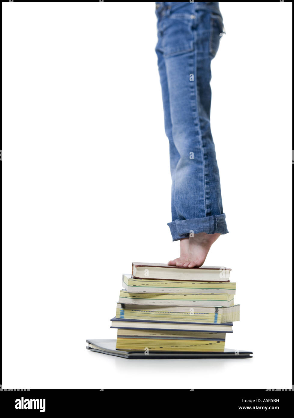 Low section view of a girl standing on a stack of books Stock Photo - Alamy