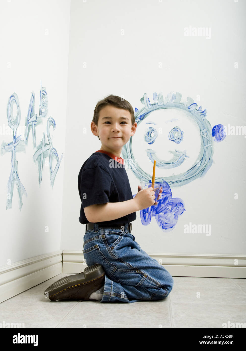 Portrait of a boy painting on a wall Stock Photo - Alamy