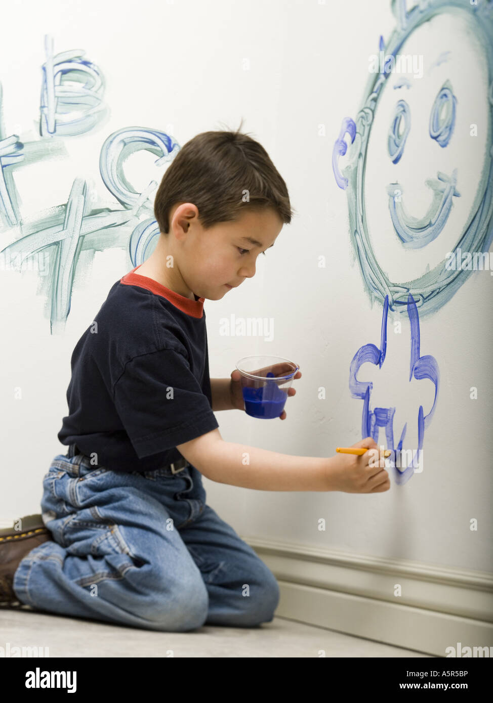 Portrait of a boy painting on a wall Stock Photo - Alamy