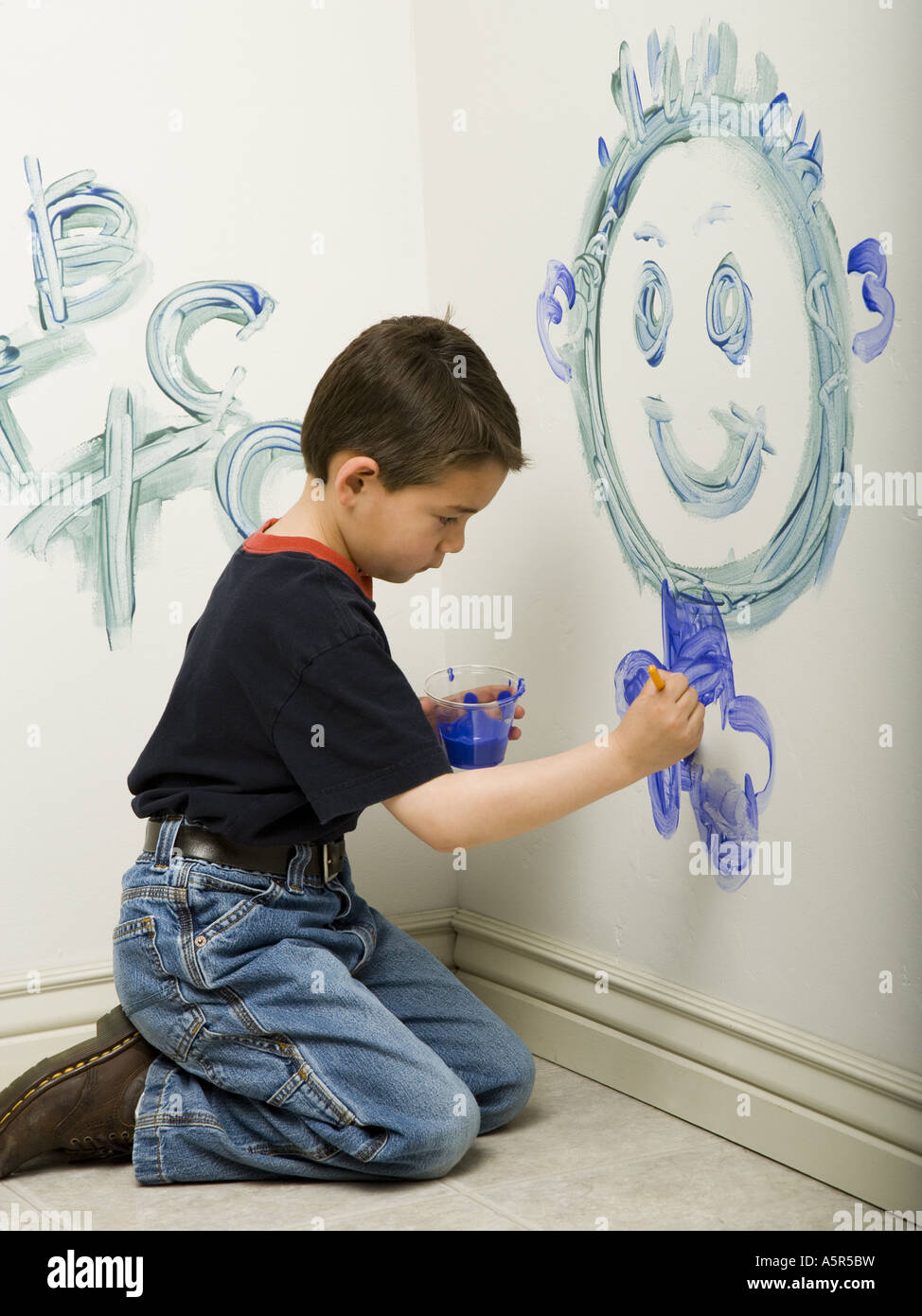 Portrait of a boy painting on a wall Stock Photo - Alamy