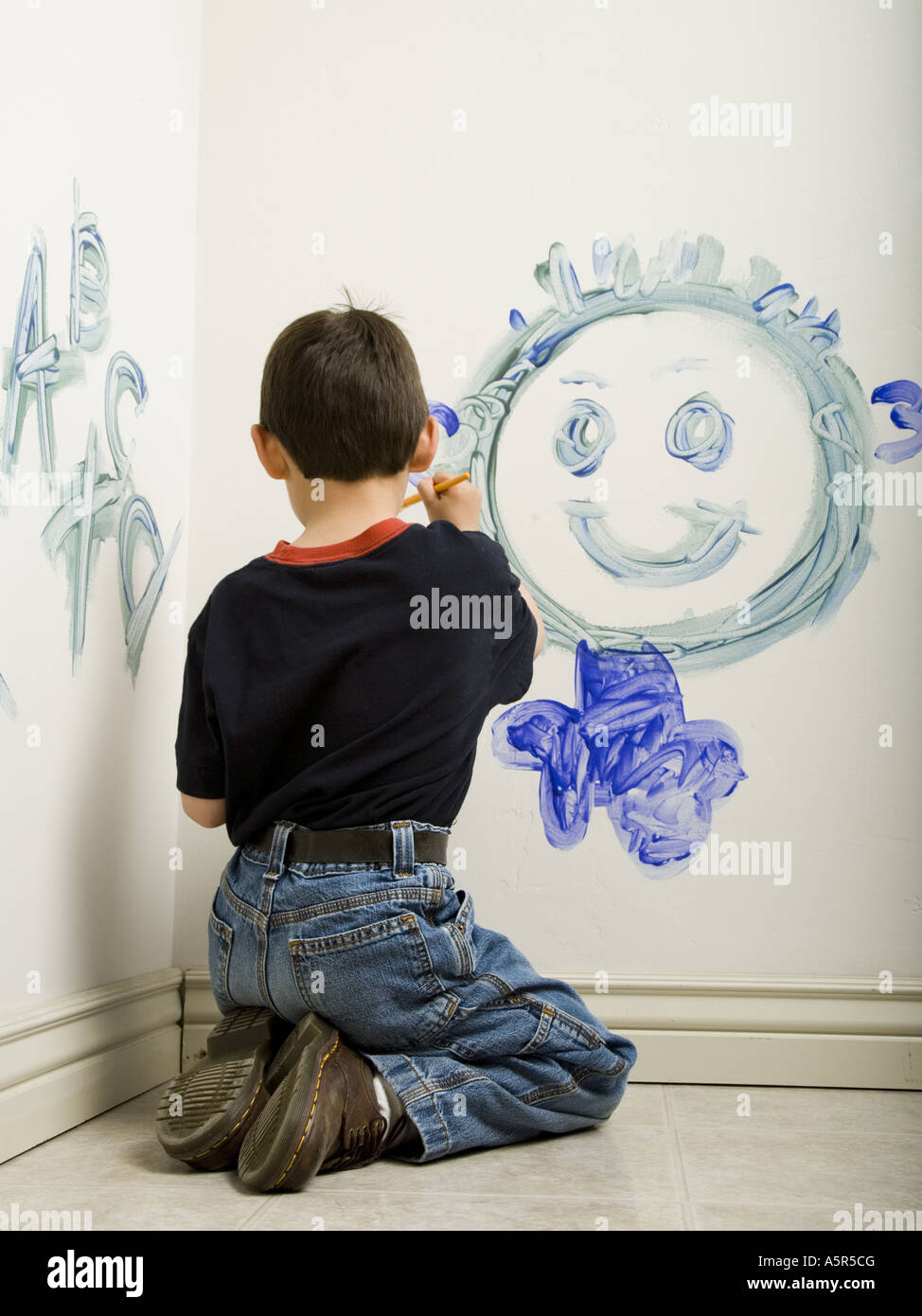 Portrait of a boy painting on a wall Stock Photo - Alamy