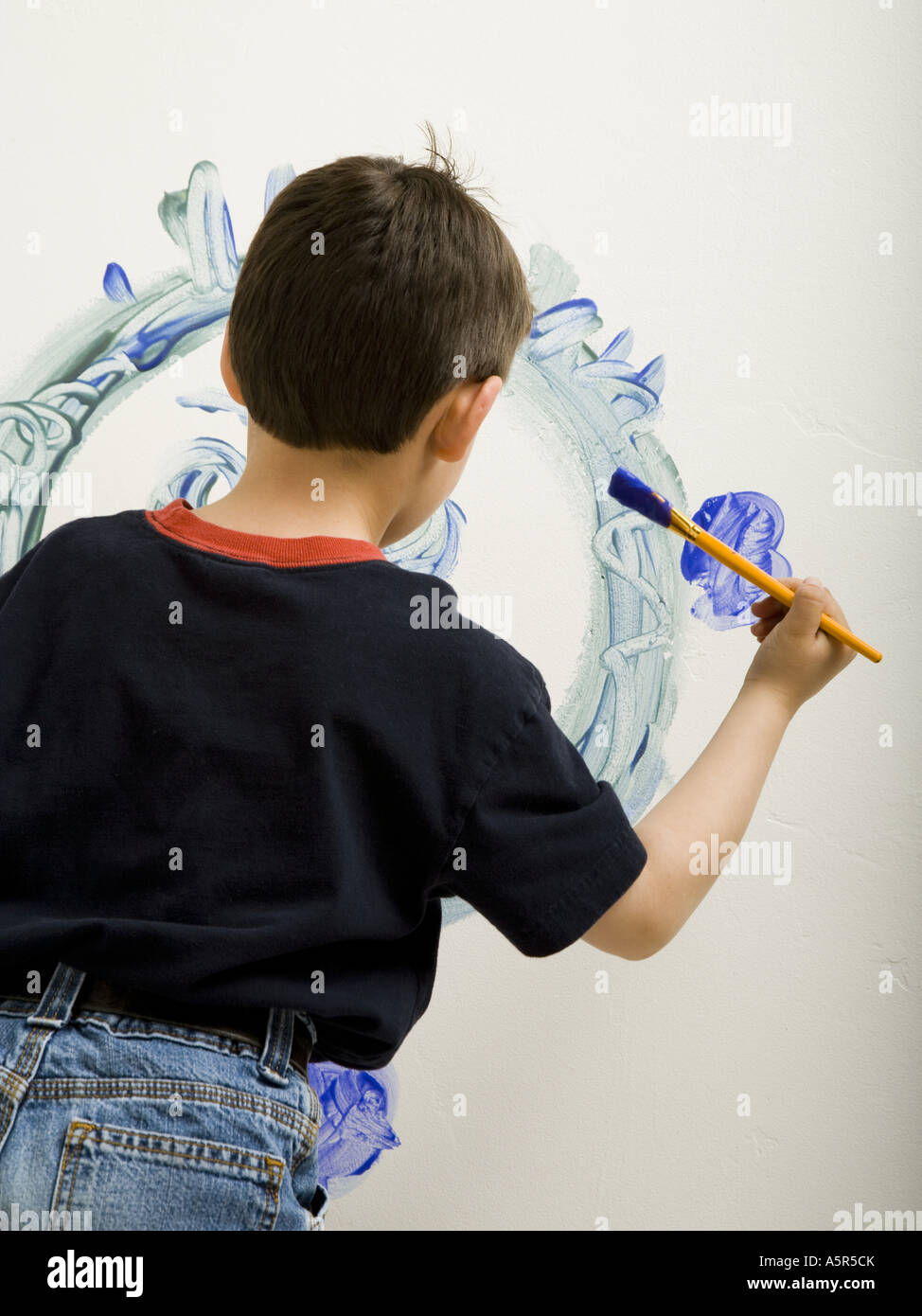 Portrait of a boy painting on a wall Stock Photo - Alamy
