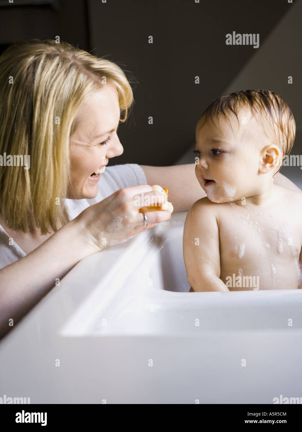 Woman bathing baby in sink Stock Photo - Alamy