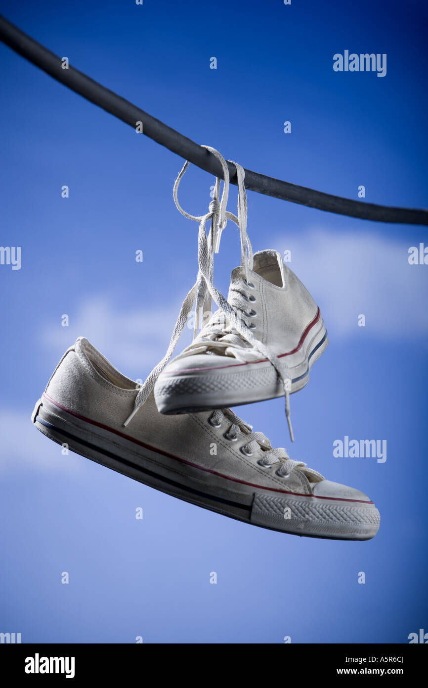 Running shoes hanging on wire outdoors with blue sky Stock Photo - Alamy