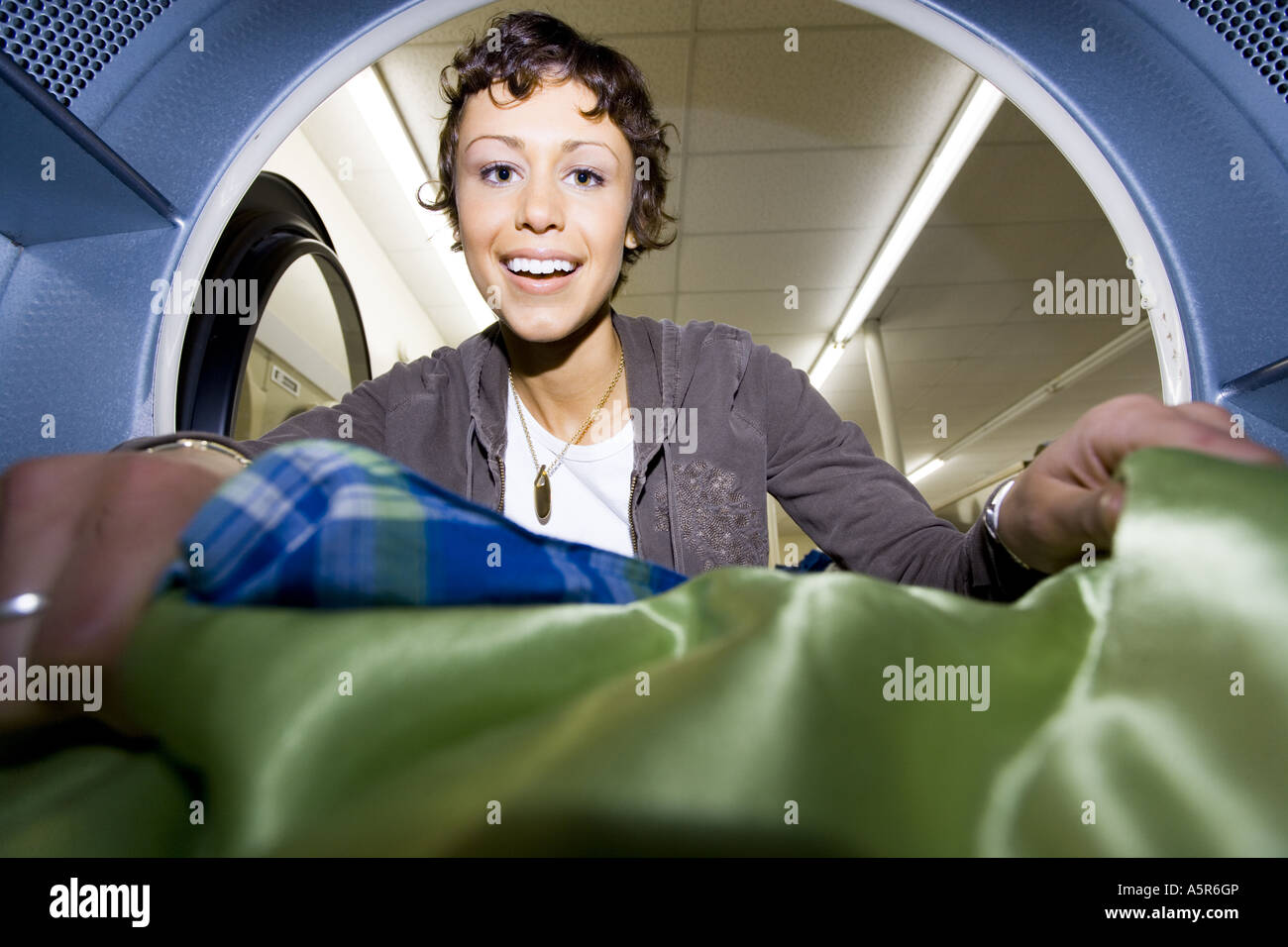 Inside dryer at Laundromat with woman removing clothing Stock Photo - Alamy