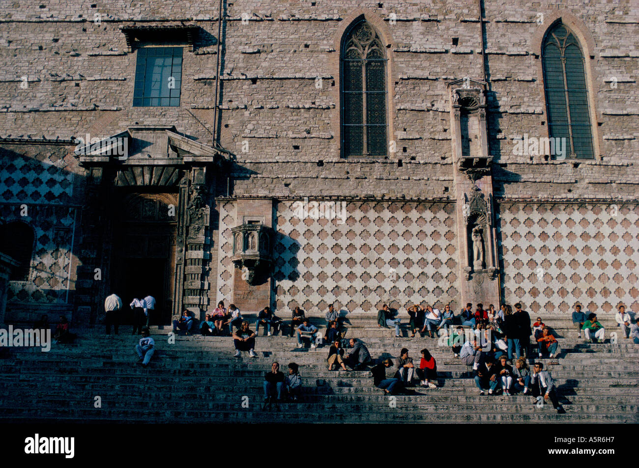 PEOPLE SITTING ON THE STEPS OUTSIDE THE PATTERNED BRICK CHURCH OF ...