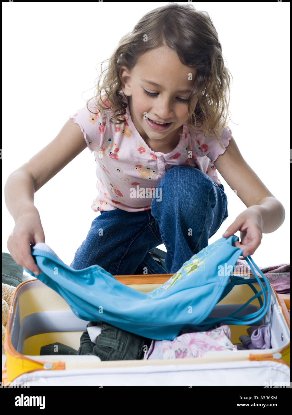 Portrait of a girl packing a suitcase Stock Photo - Alamy