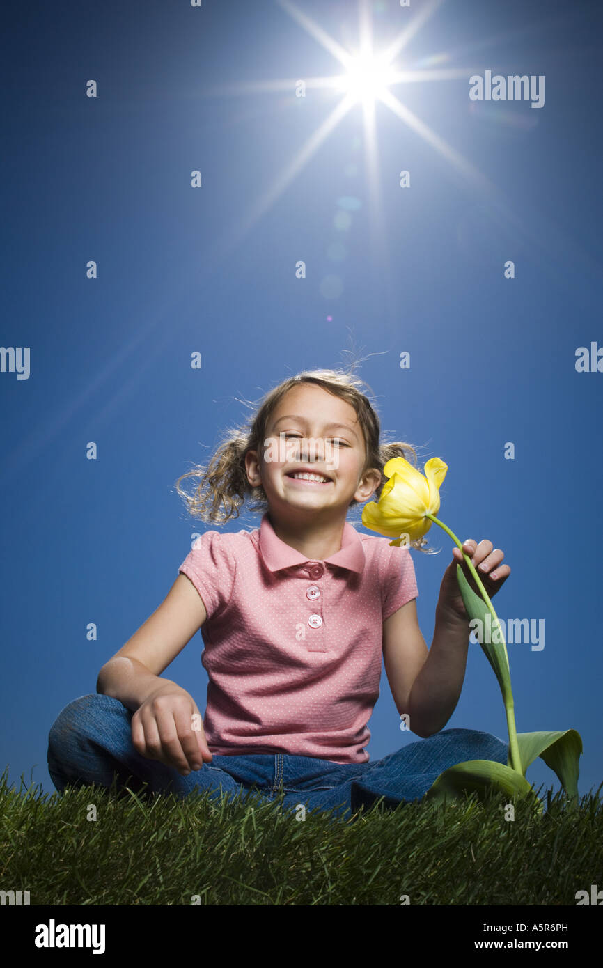 Portrait of a girl sitting beside a flower Stock Photo - Alamy