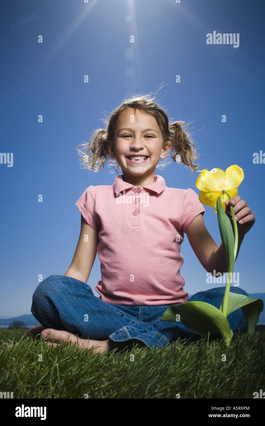 Portrait of a girl sitting beside a flower Stock Photo - Alamy