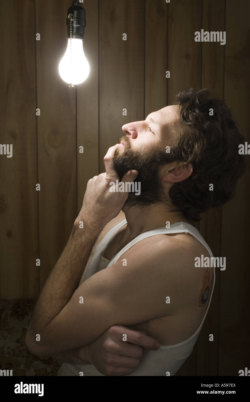 Man looking thoughtfully at light bulb Stock Photo - Alamy
